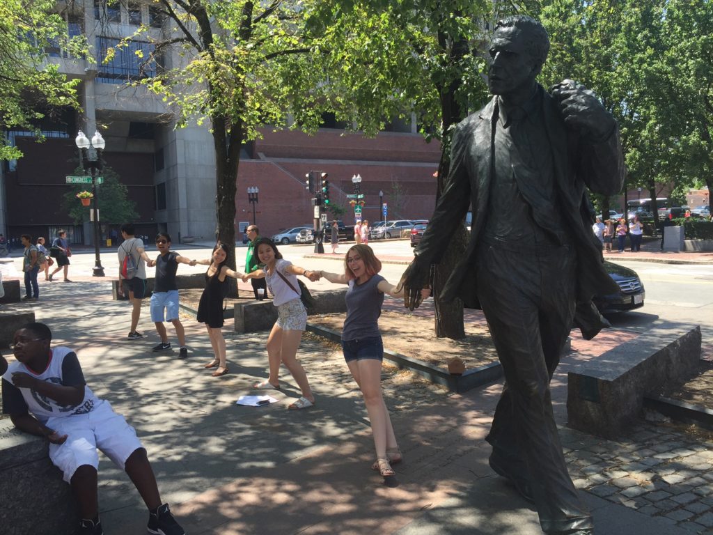 Players on the Secrets of Old Boston Scavenger Hunt pose for a photo challenge with a statue ...